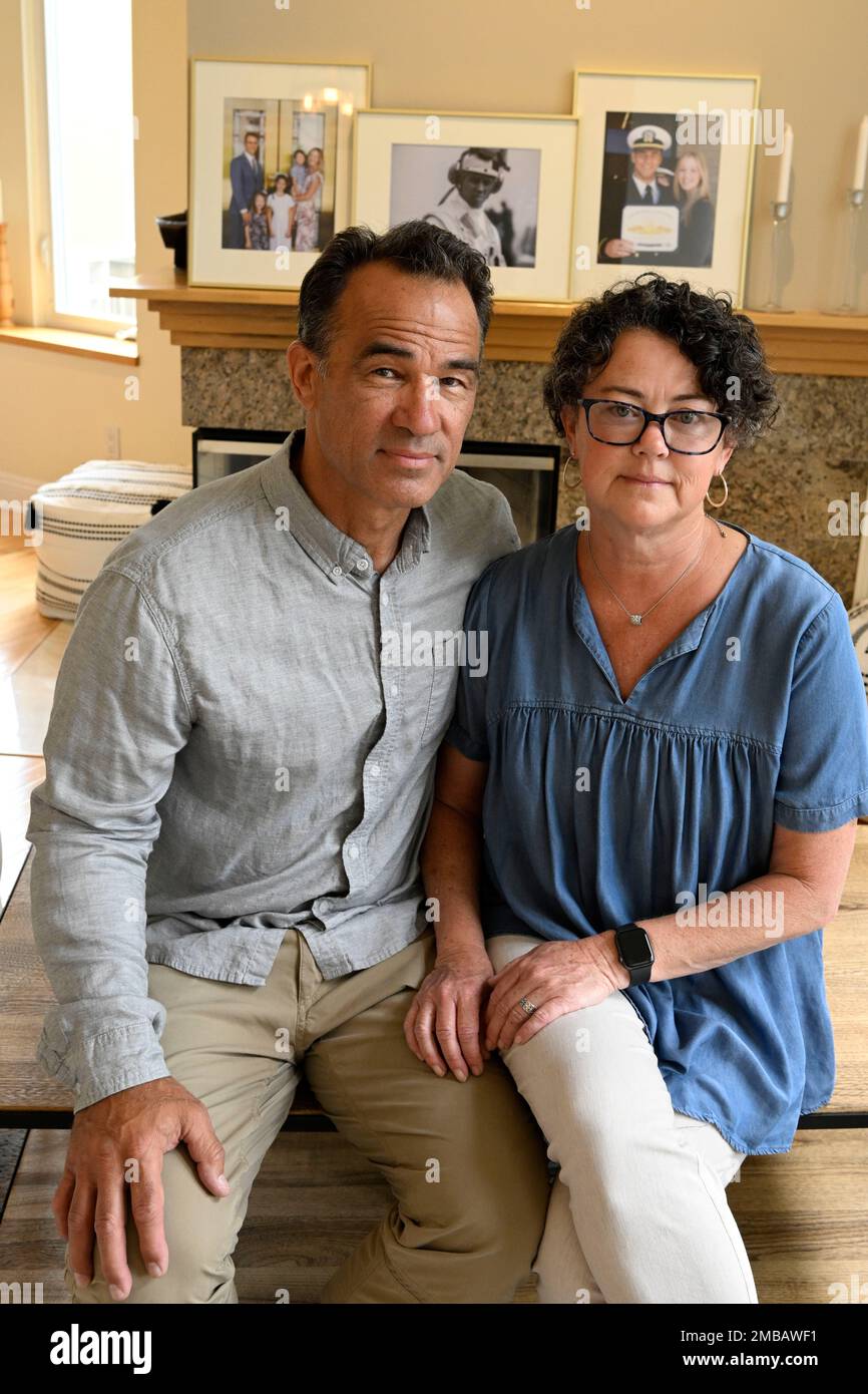 Derek and Suzi Alkonis pose in front of photos of their son Lt. Ridge ...