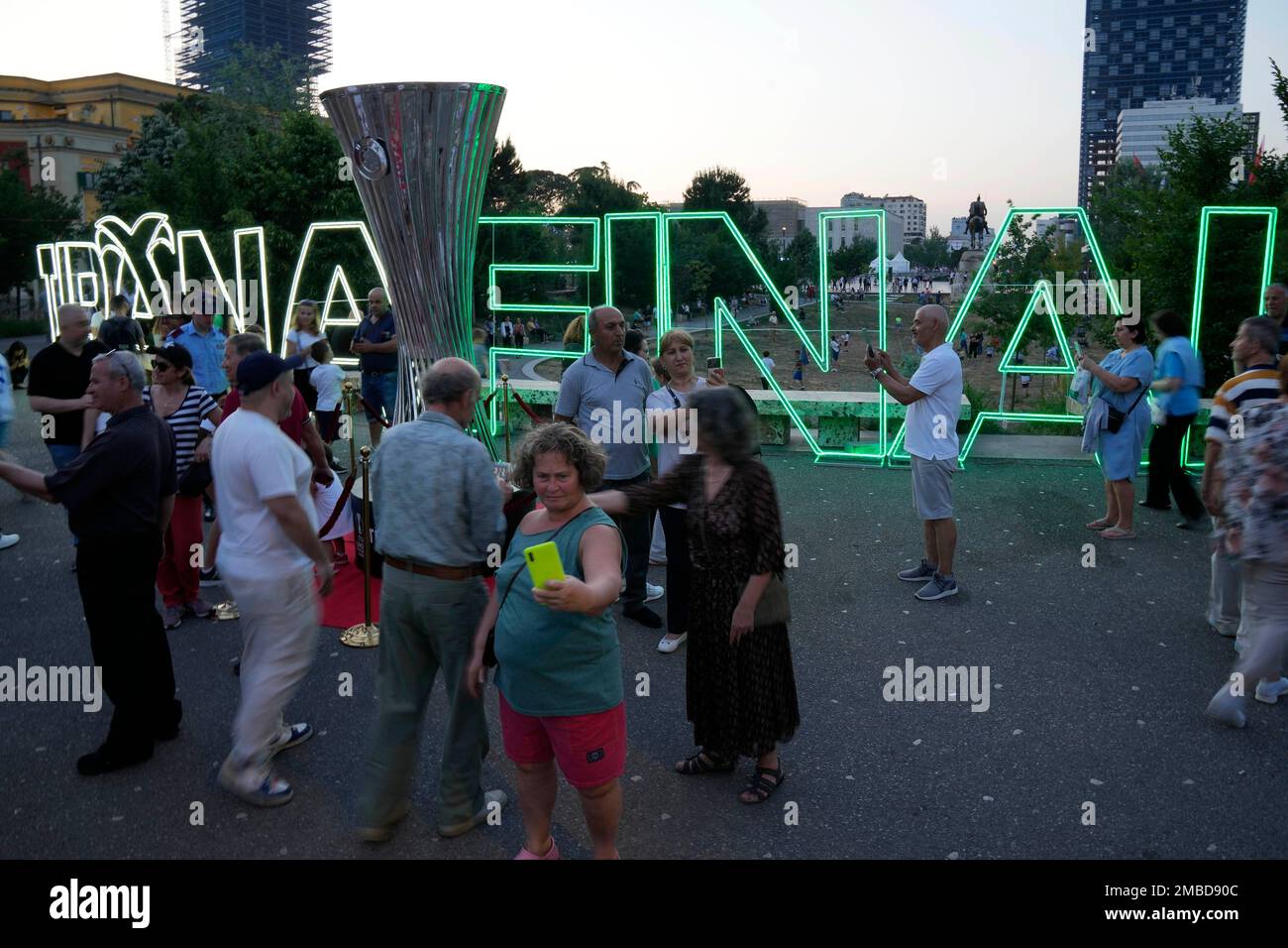 People pose for pictures next to a copy of Conference League trophy in ...