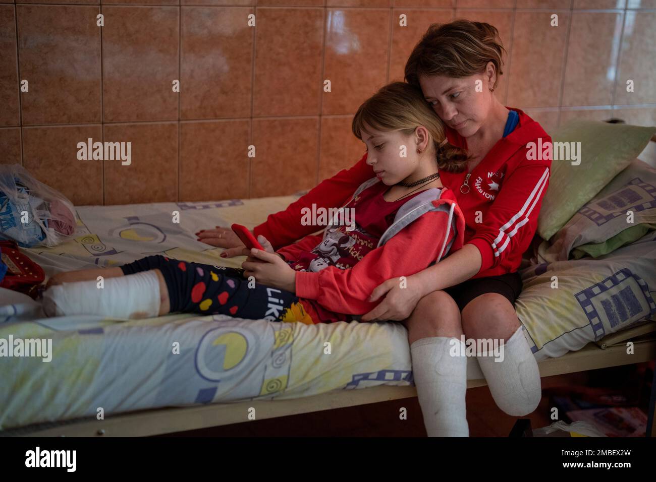 Natasha Stepanenko, 43, sits on her bed with her daughter Yana, 11, at ...