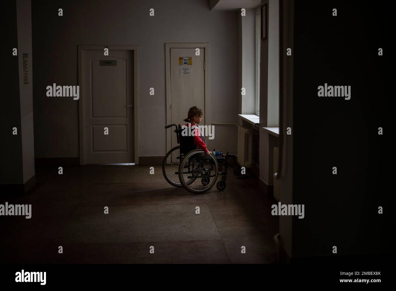 Yana Stepanenko, 11, sits next to the window on her wheelchair at a ...