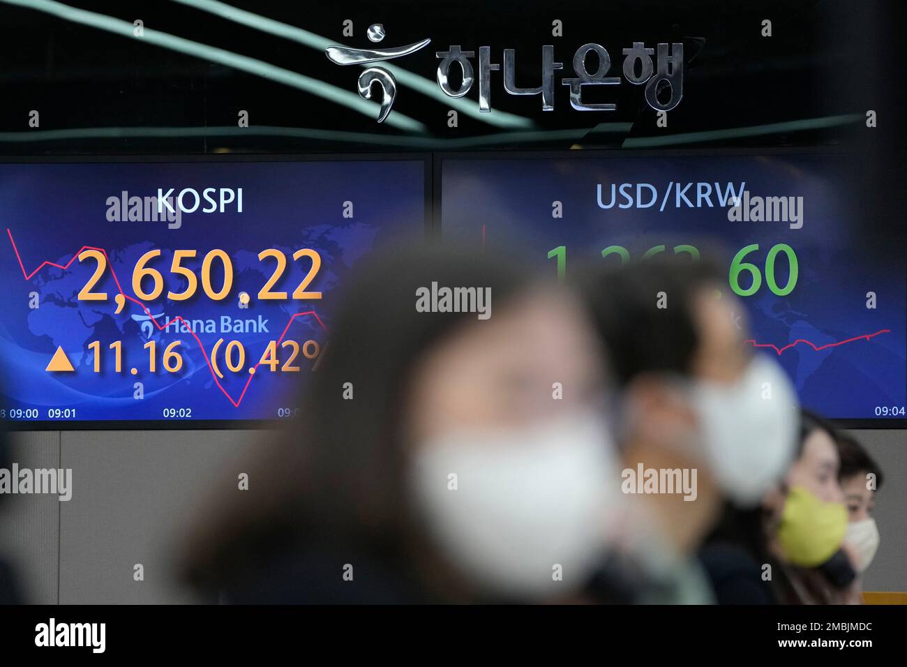 Currency traders watch computer monitors near the screen showing the ...