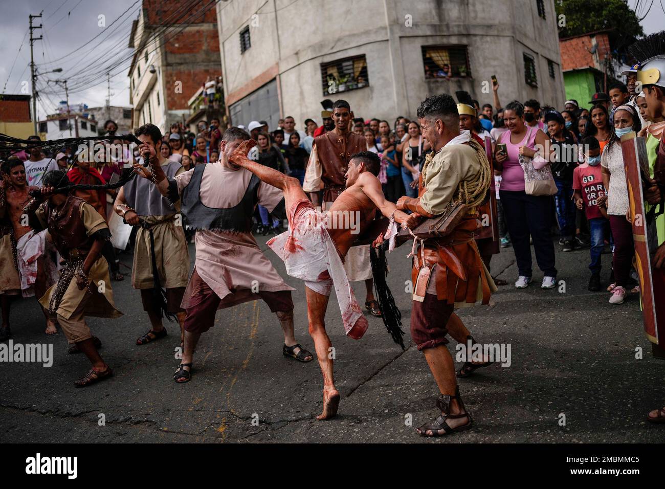 A devotee dressed as a Roman soldier whips a penitent playing the role ...