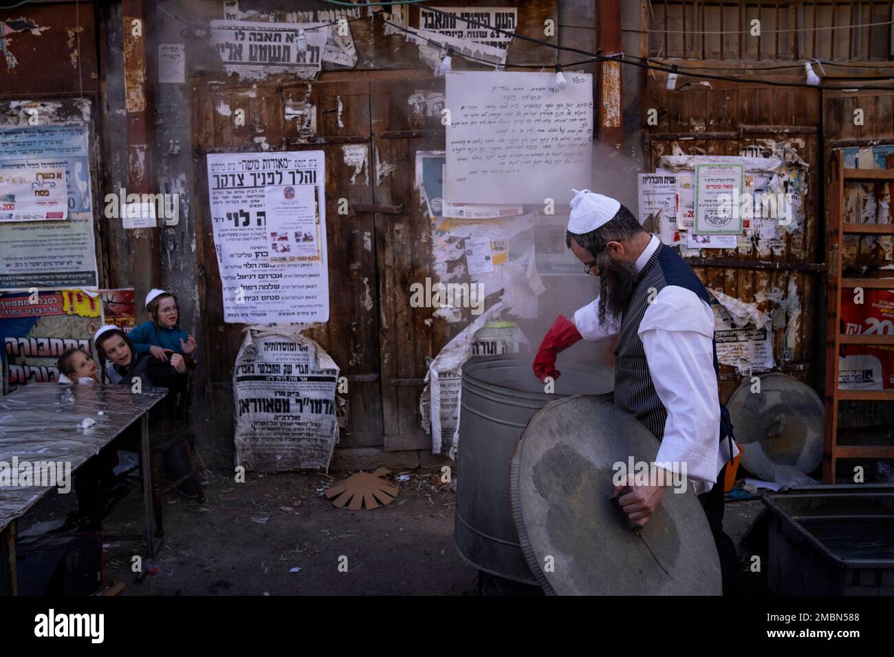 An ultra-Orthodox Jewish man dips cooking utensils in boiling water to ...