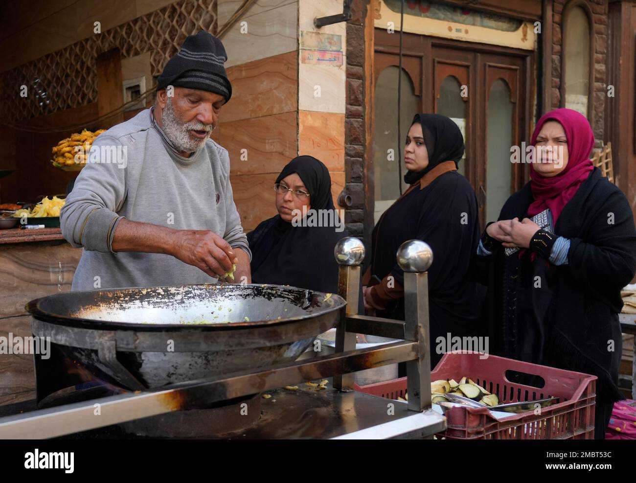 Women waits to buy fried fava beans,in Shoubra district, in Cairo ...