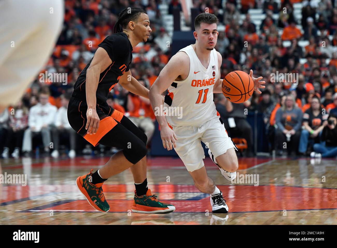 Syracuse guard Joseph Girard III, right, is defended by Miami guard ...