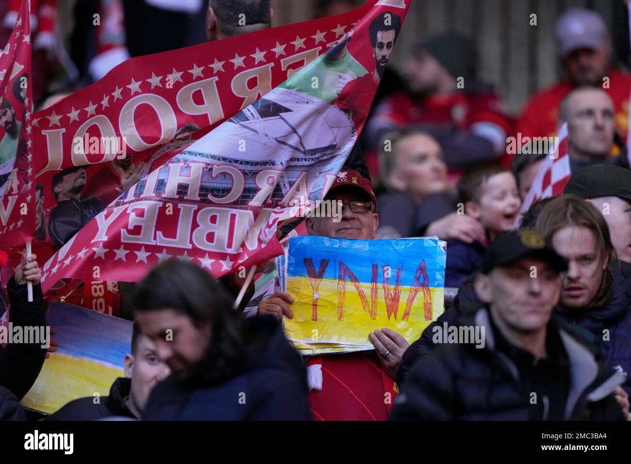 A Liverpool fan holds a sign in the Ukrainian colors with the initials ...