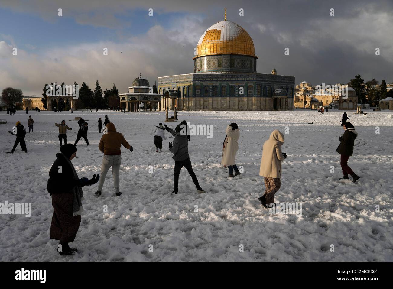 Palestinians enjoy the snow next to the Dome of the Rock Mosque in the ...