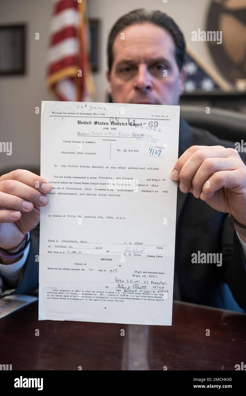 U.S. Marshal Peter J. Elliott holds the original warrant from 1969 for ...