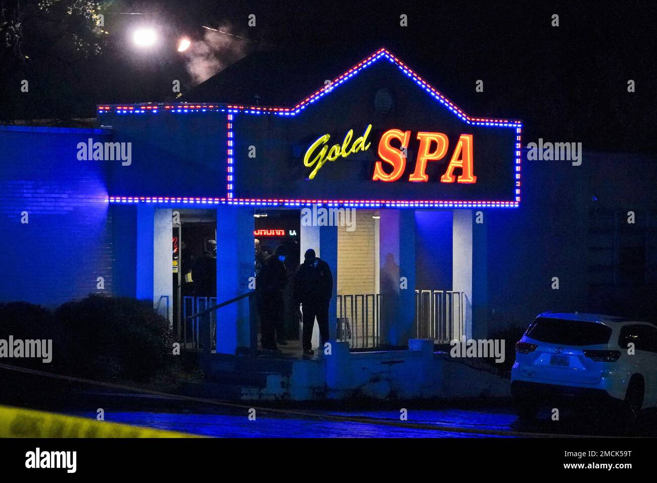 FILE - Law enforcement officials confer outside a massage parlor ...