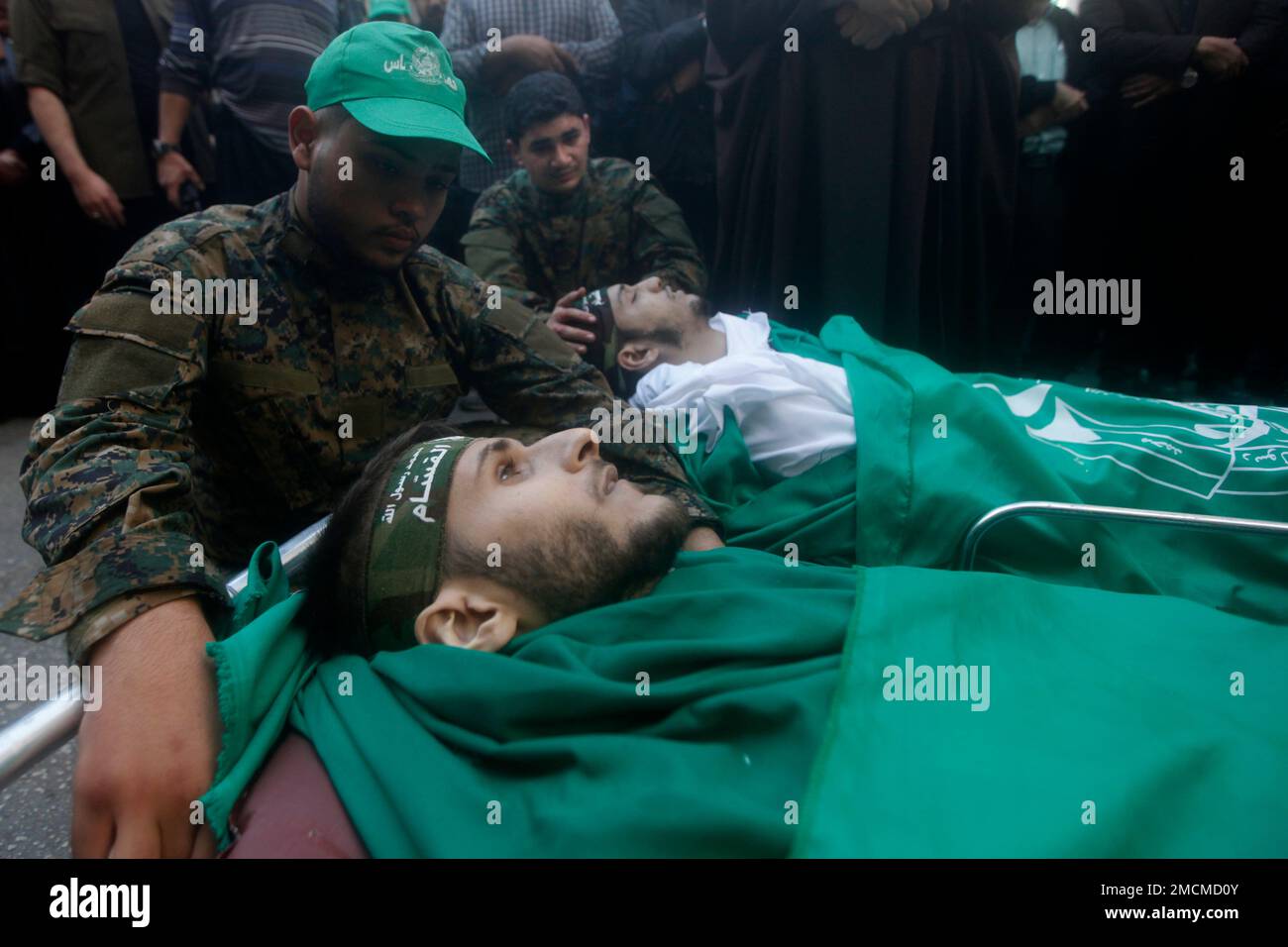 Hamas fighters mourn next the bodies of their comrades who were killed ...