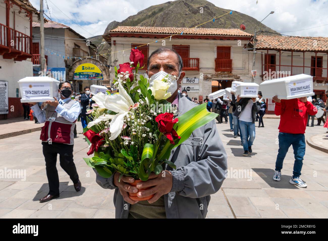 Zenon Osnayo carries a bouquet of flowers as he leads a funeral ...