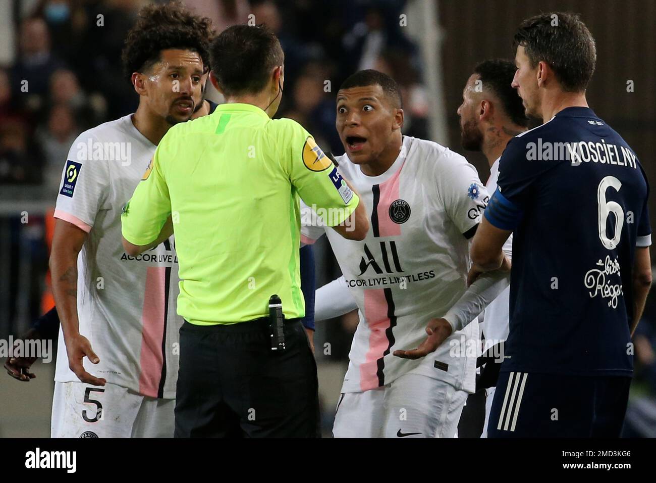 PSG's Kylian Mbappe, center, reacts as he gets a yellow card from ...