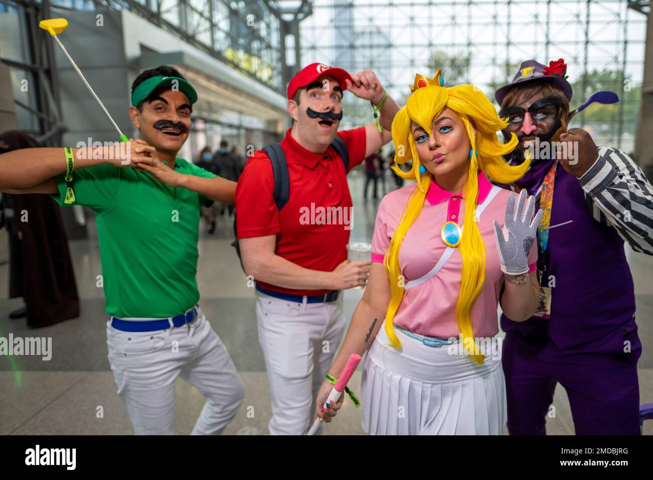 Attendee dressed as video game characters Luigi, left, Mario, Princess Peach and Wario pose ...