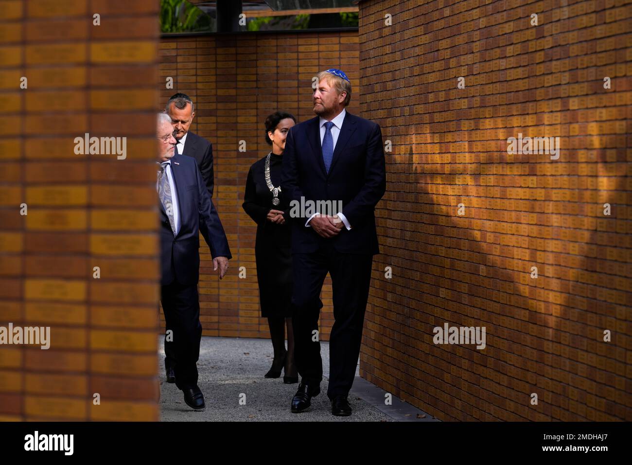 King Willem-Alexander, right, walks along walls with name stones after ...
