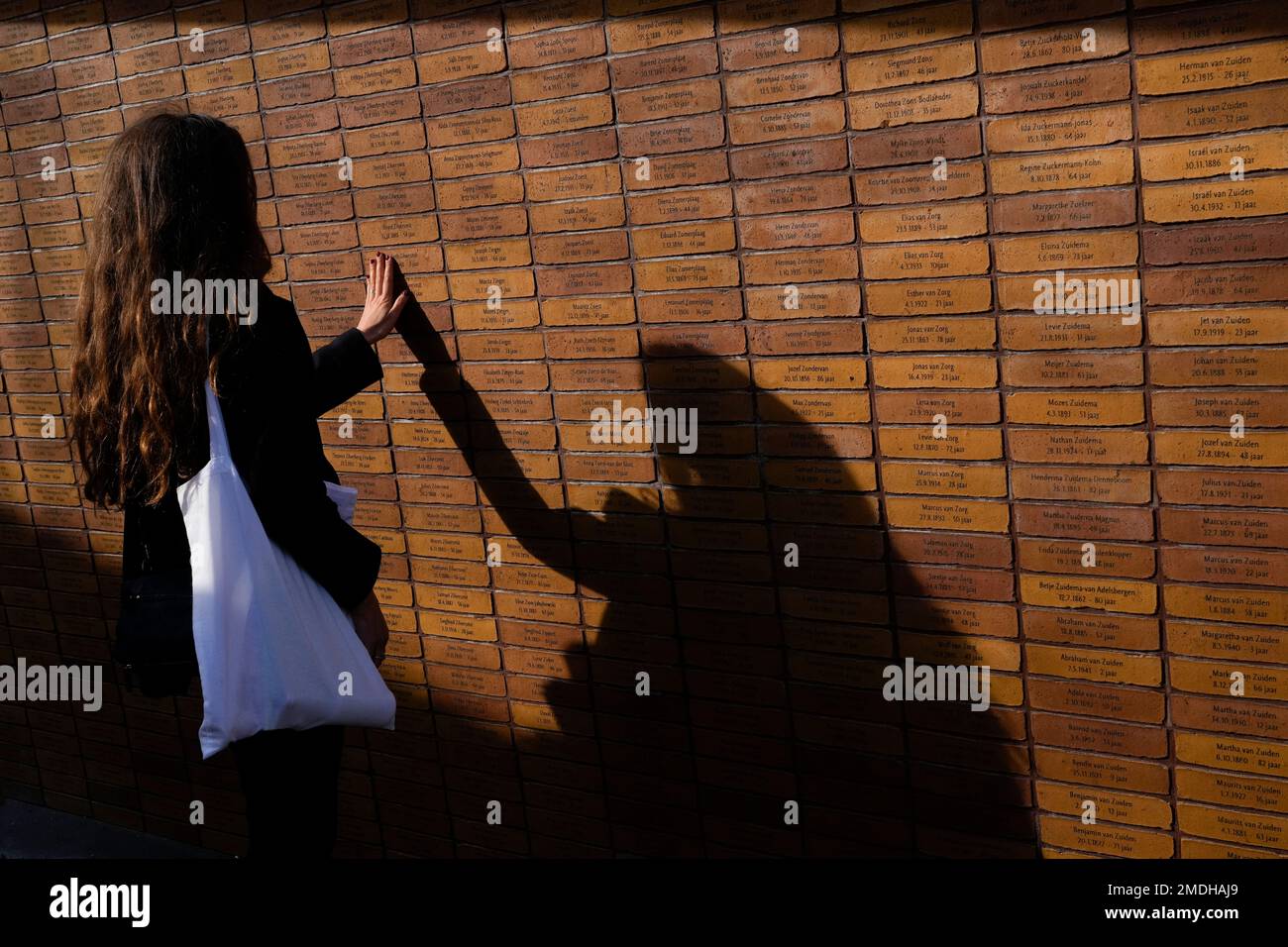 A woman touches one of the name stones after King Willem-Alexander ...