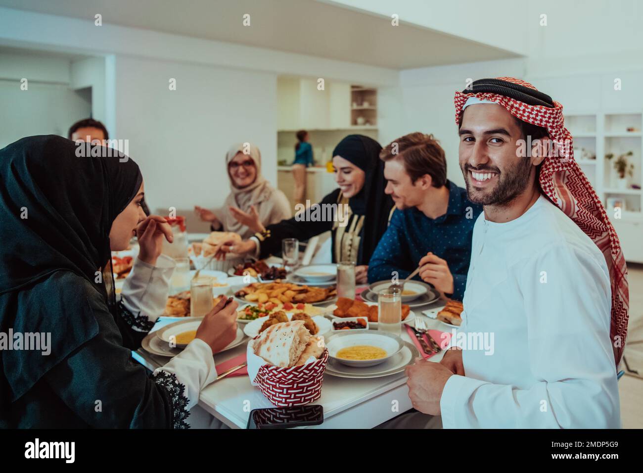 Muslimische Familie, die Iftar zum Essen trinkt, um das Festmahl zu unterbrechen. Traditionelles ...
