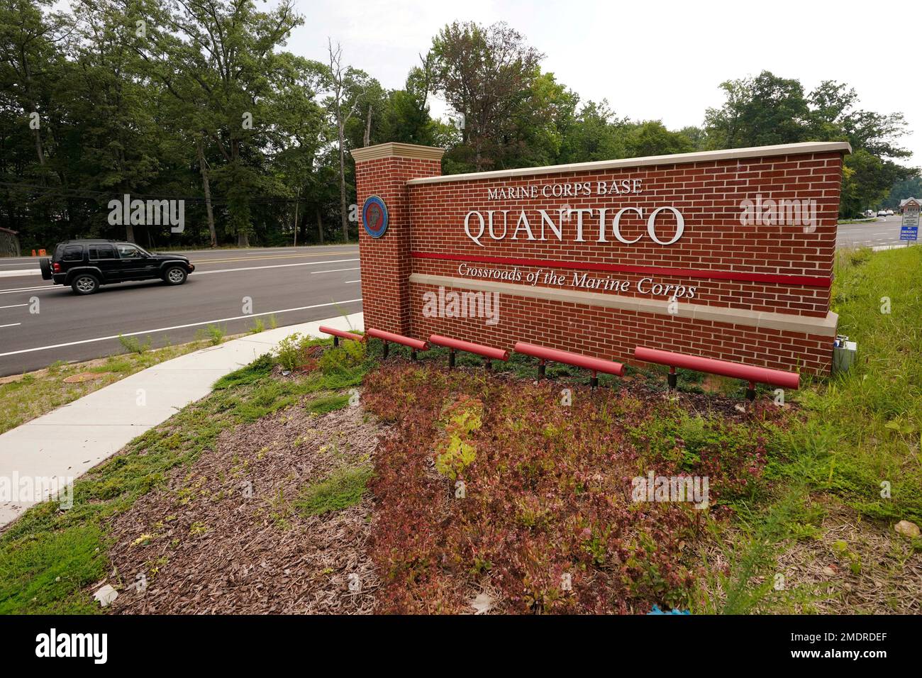 Traffic drives past the entrance sign of Marine Corps Base Quantico ...