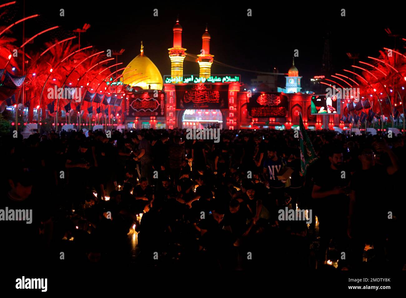 Shiite faithful pilgrims light candles outside the holy shrine of Imam ...