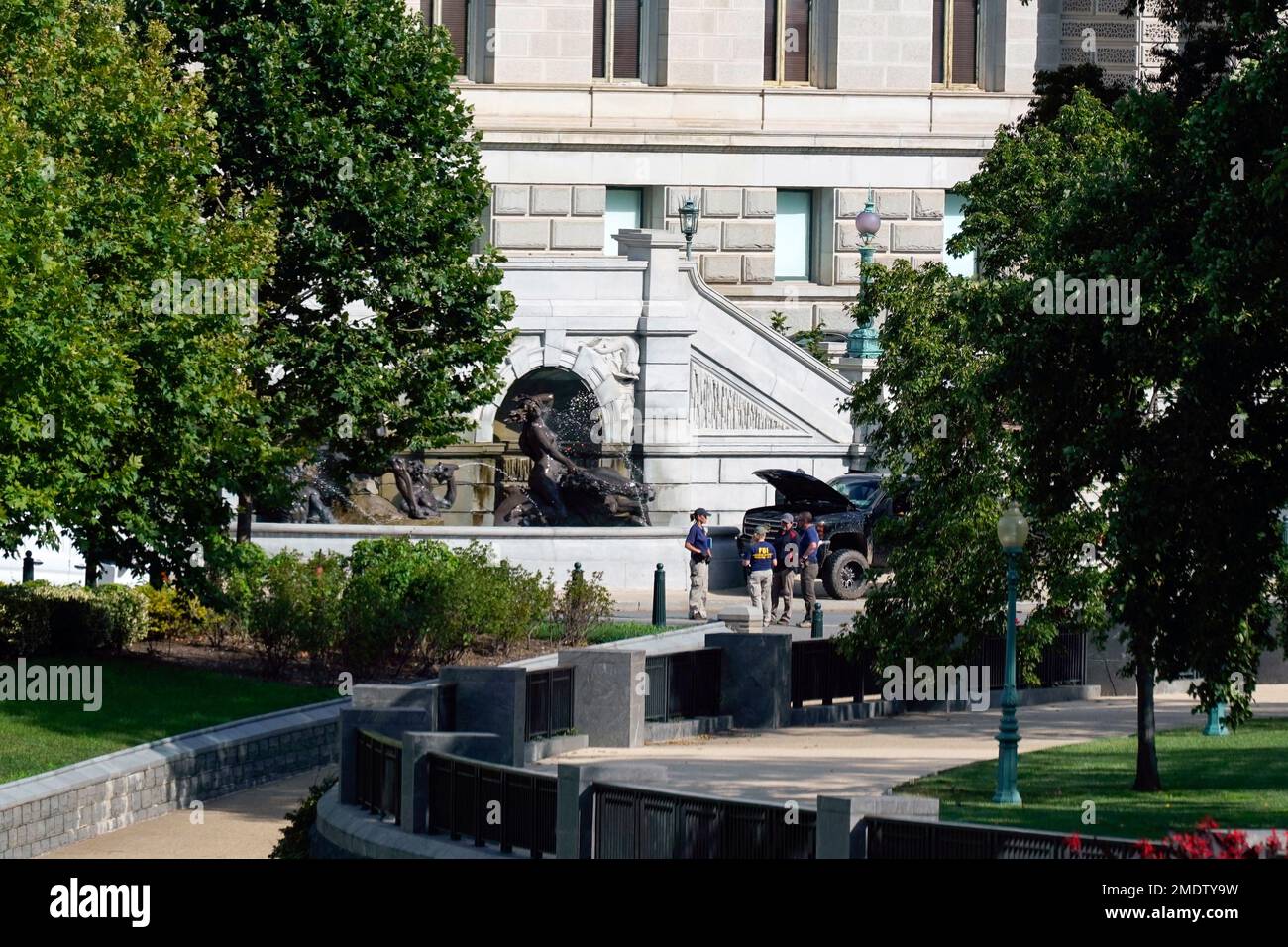 Authorities investigate a pickup truck parked on the sidewalk in front of the Library of ...