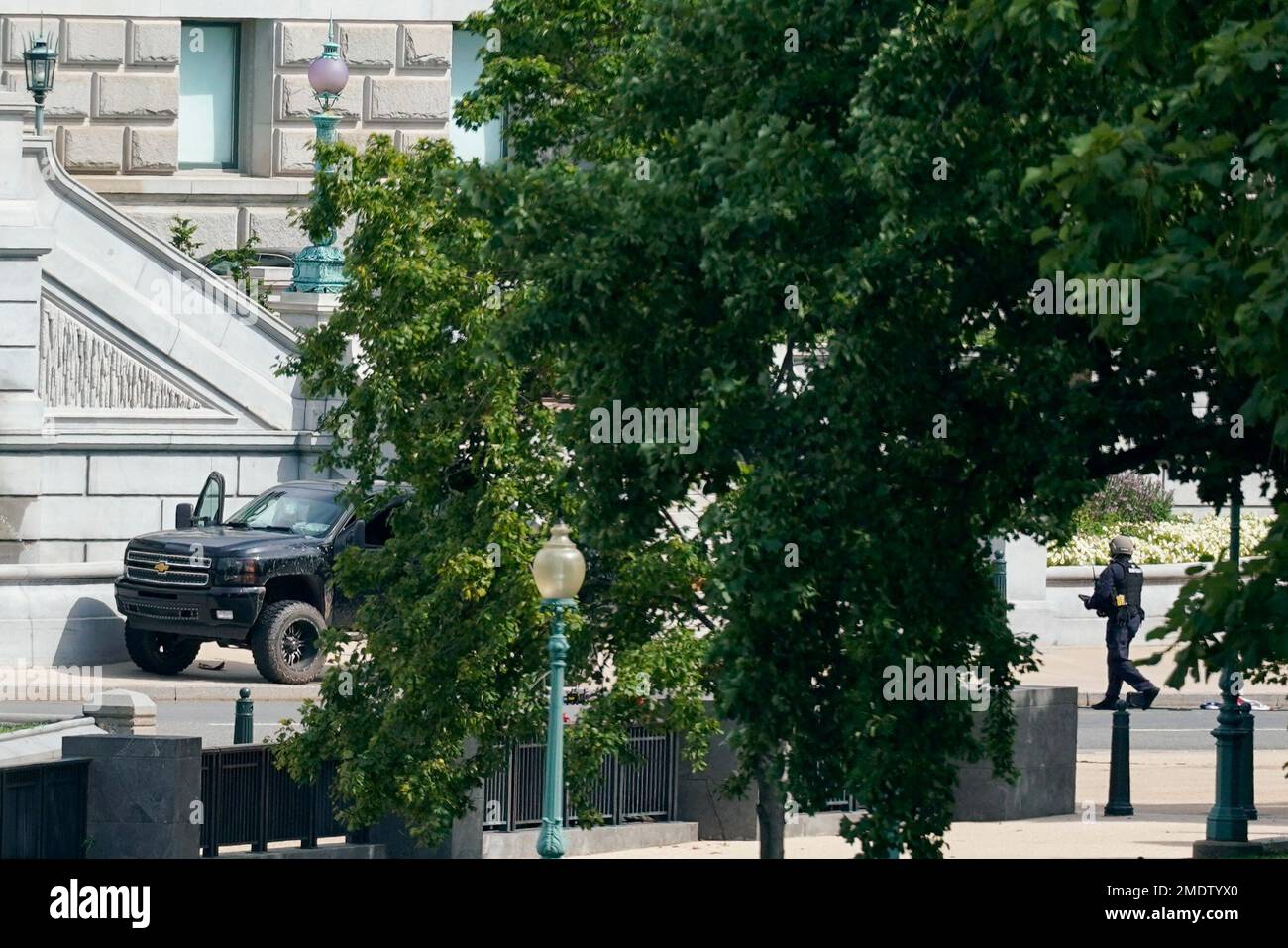 Authorities investigate a pickup truck parked on the sidewalk in front of the Library of ...