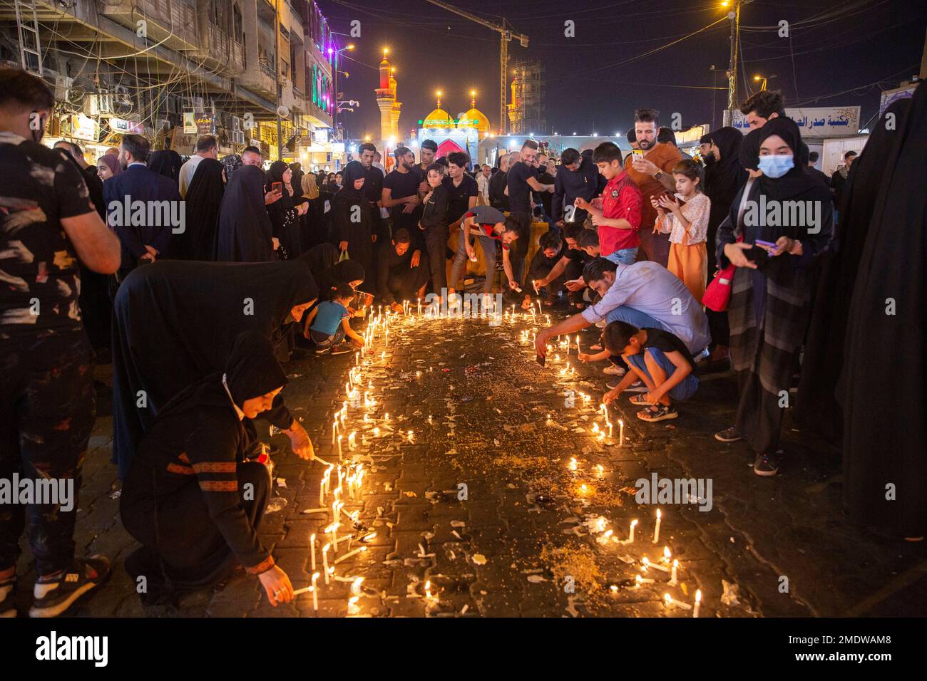 Shiite faithful pilgrims light candles outside the shrine of Imam ...