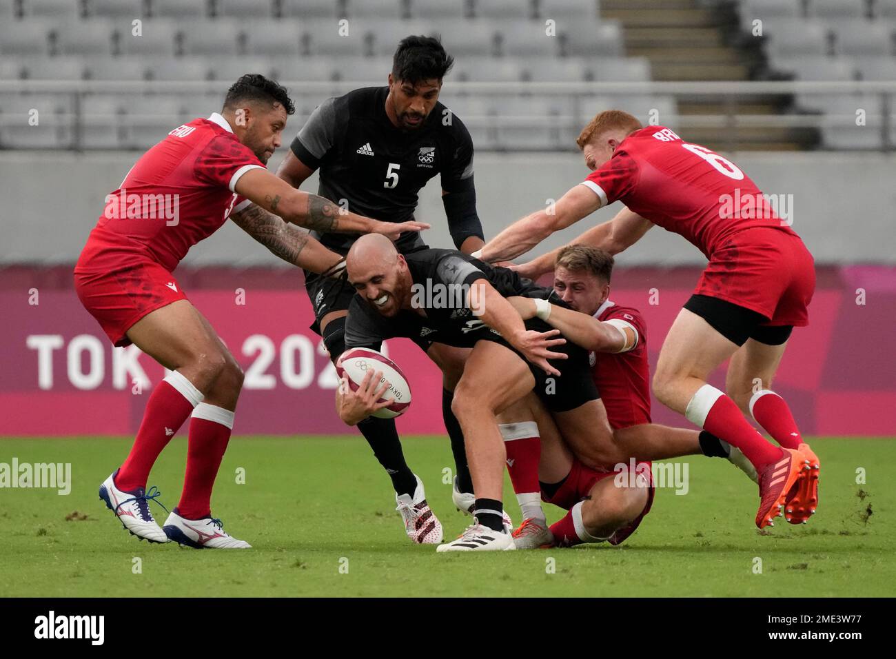 New Zealand's Joe Webber struggles to evade Canada's Mike Fuailefau ...