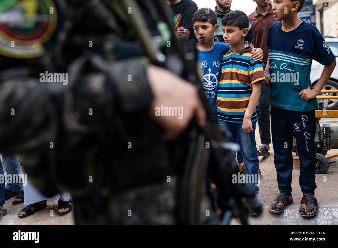 Children watch as Hamas militants parade through the streets for Bassem ...