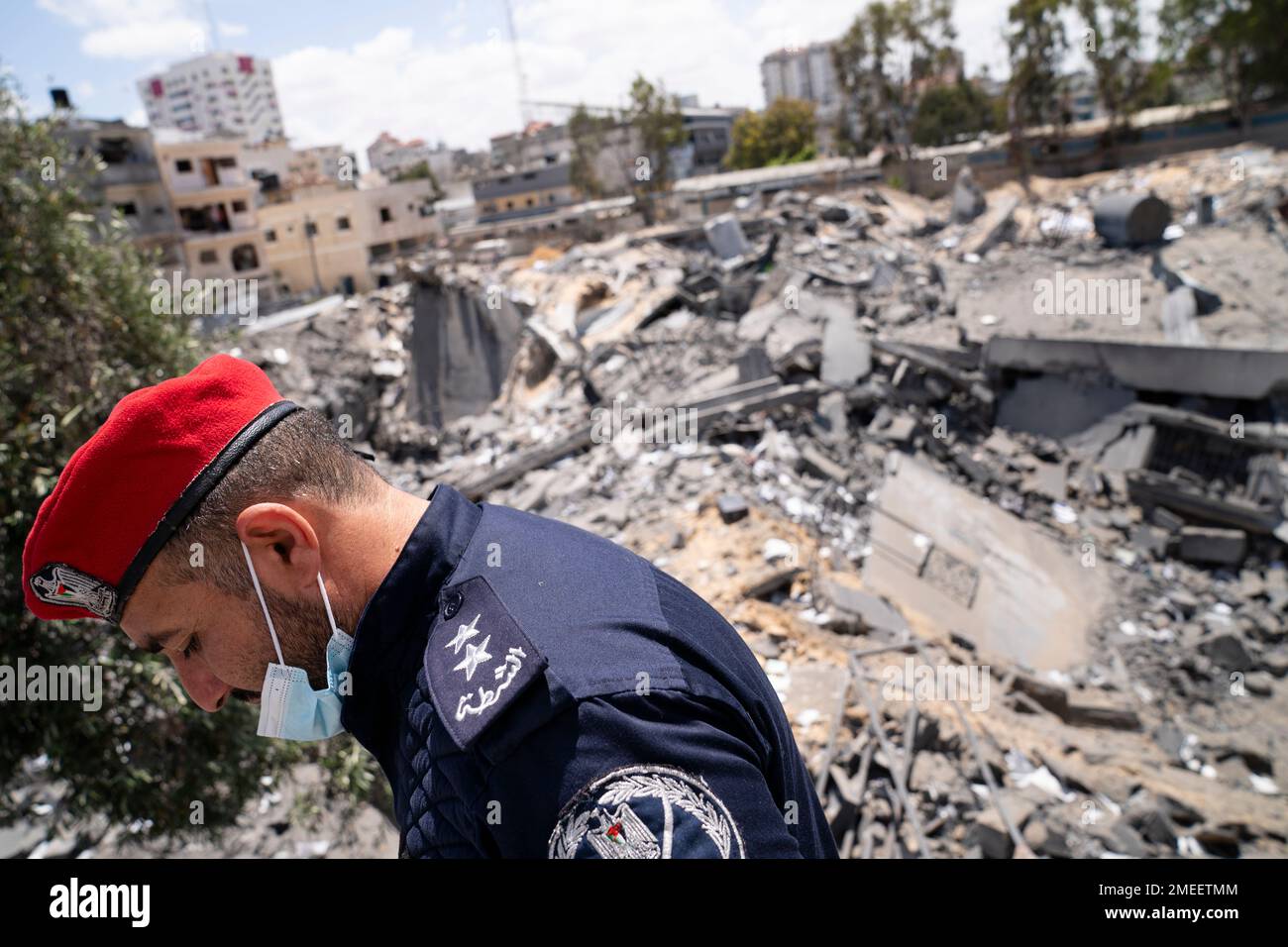 A Hamas police officer passes an crater of an airstrike that destroyed ...