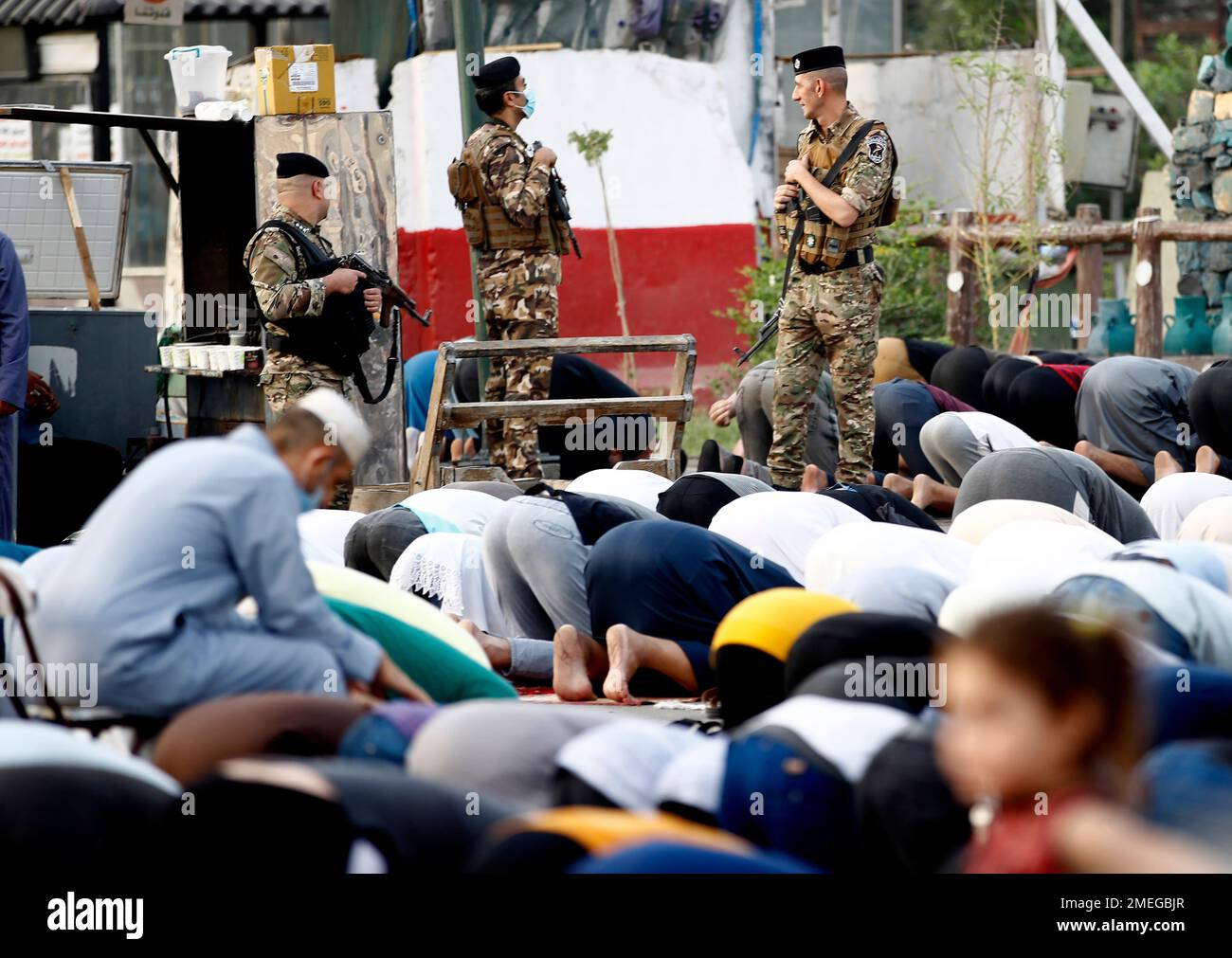 Security forces stand guard while Muslims perform Eid prayers on the ...