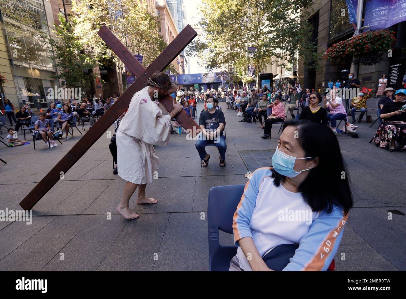 A parishioner, right, wears a mask as actor Timothy Watkins carries a ...