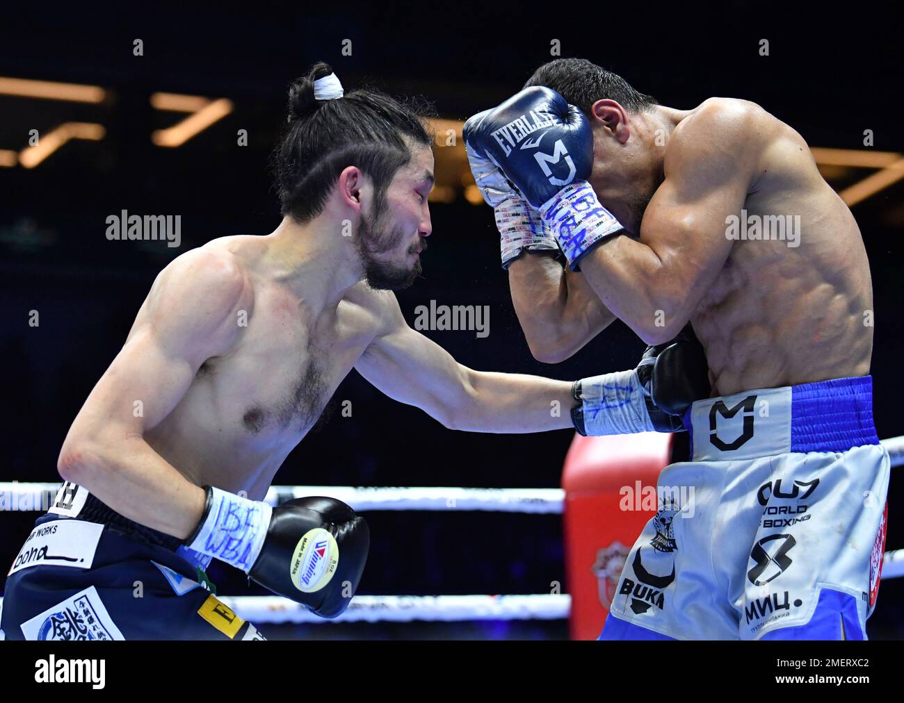 Japan's Ryosuke Iwasa, left, punches Uzbekistan's Murodjon Akhmadaliev ...