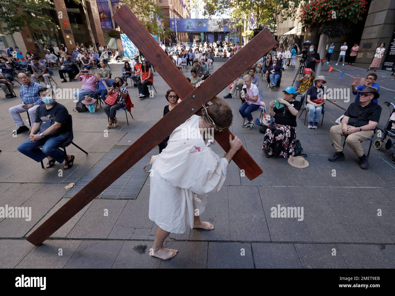 Actor Timothy Watkins carries a cross during his portrayal of Jesus ...