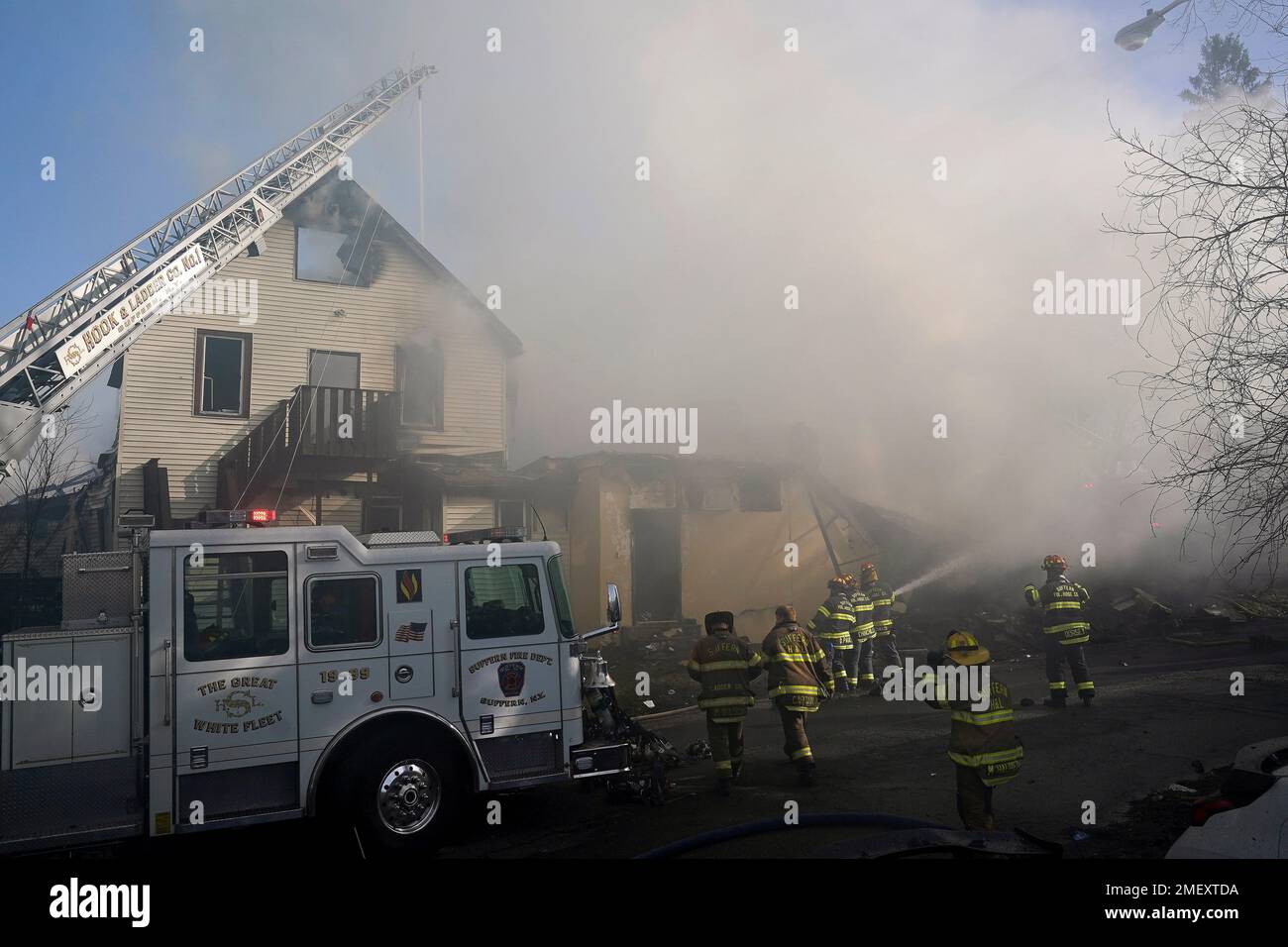 Firefighters work on extinguishing hotspots from a fire that burned ...