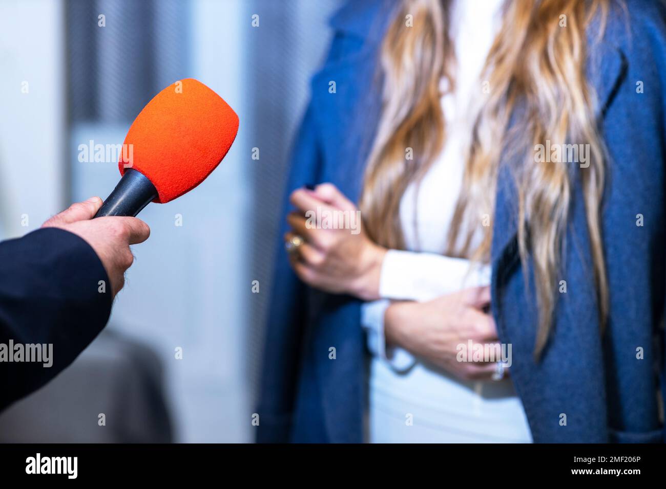 TV-Reporterin, die ein Interview mit einer nicht erkennbaren Frau macht ...