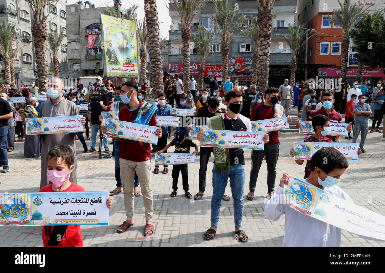 Hamas supporters wear face masks while holding placards during a ...