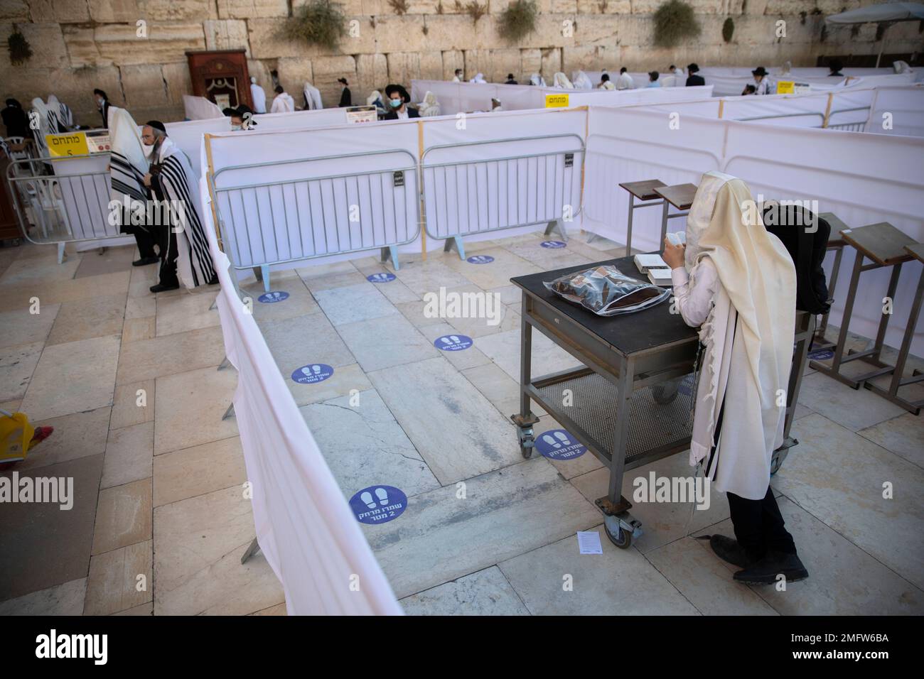 Ultra-Orthodox Jewish men covered in prayer shawls pray in divided ...
