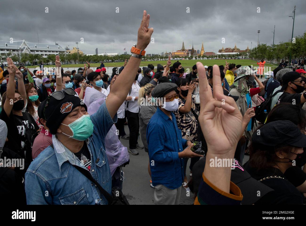 Demonstrators raise a three-finger symbol of resistance salute as they ...