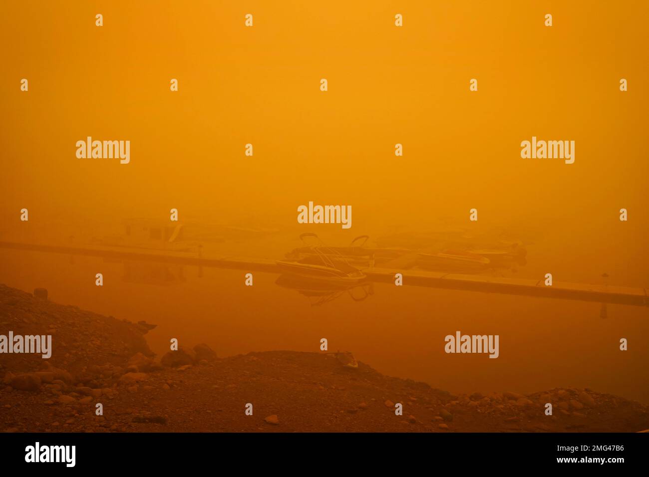 Boats are partially obscured by smoke from a wildfire at a marina on ...