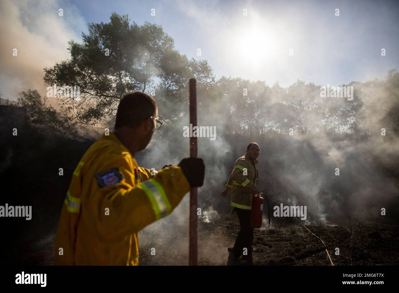 Firefighters attempt to extinguish a fire started by an incendiary ...