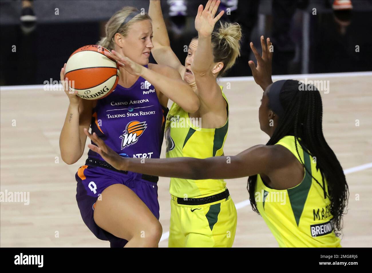 Phoenix Mercury's Sophie Cunningham, left, goes up against the defense of Seattle Storm's Sami ...