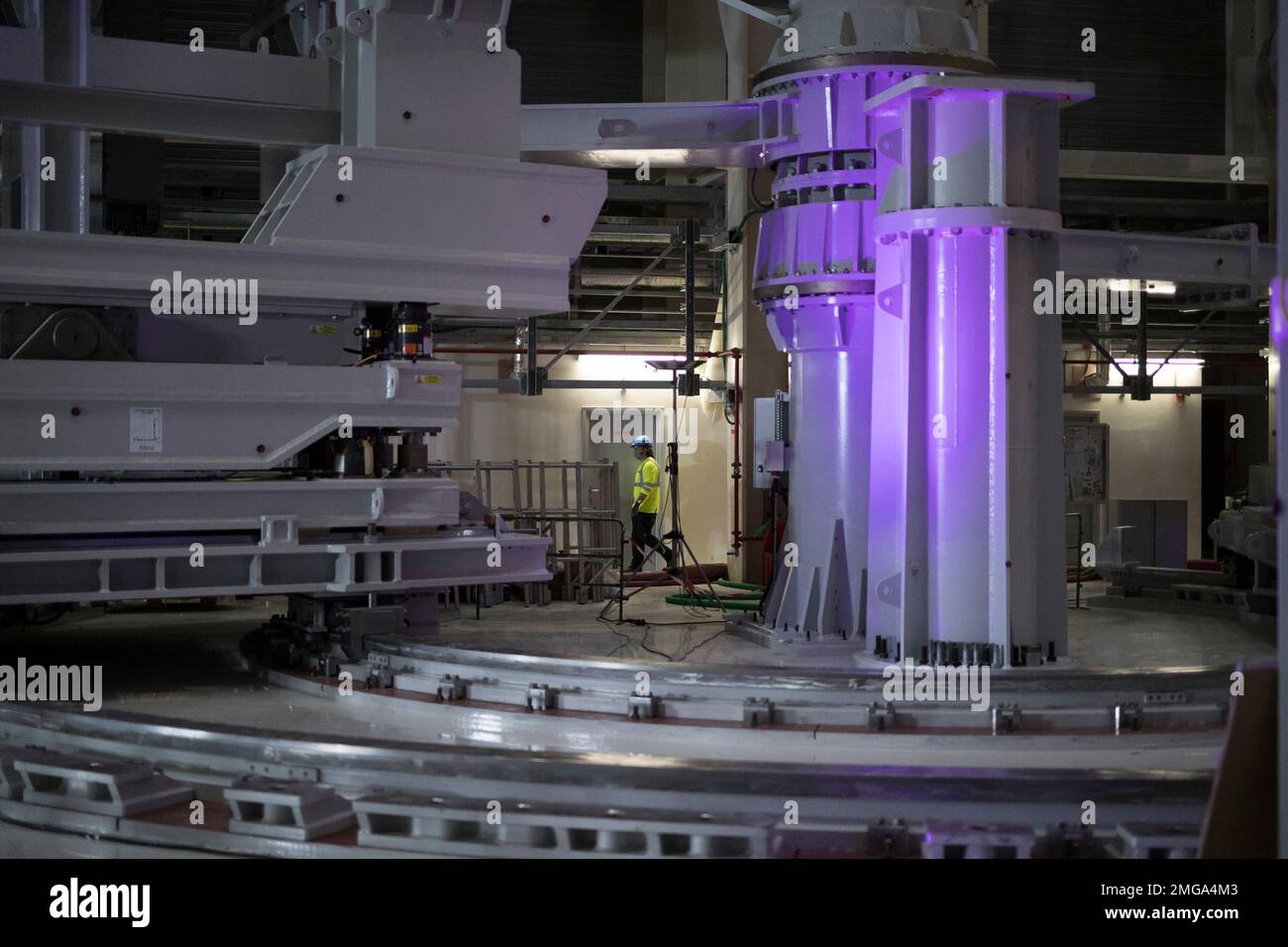 A worker walks through large scale assembly tools in the assembly hall ...