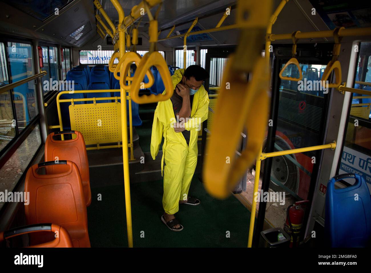 A Nepalese bus driver wears protective gear before sitting down to ...