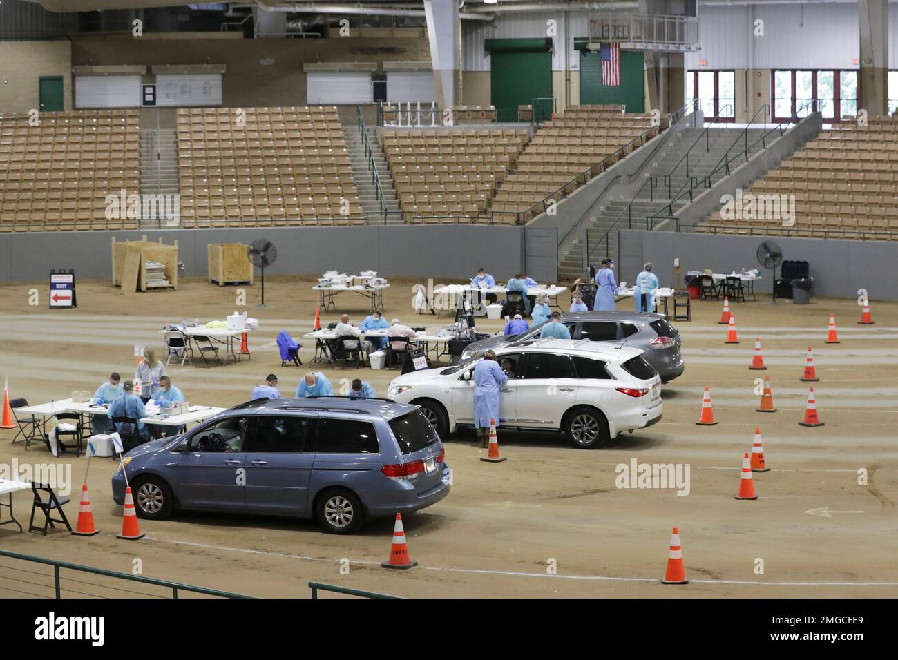 Workers administer COVID-19 tests at a drive-through facility set up in ...