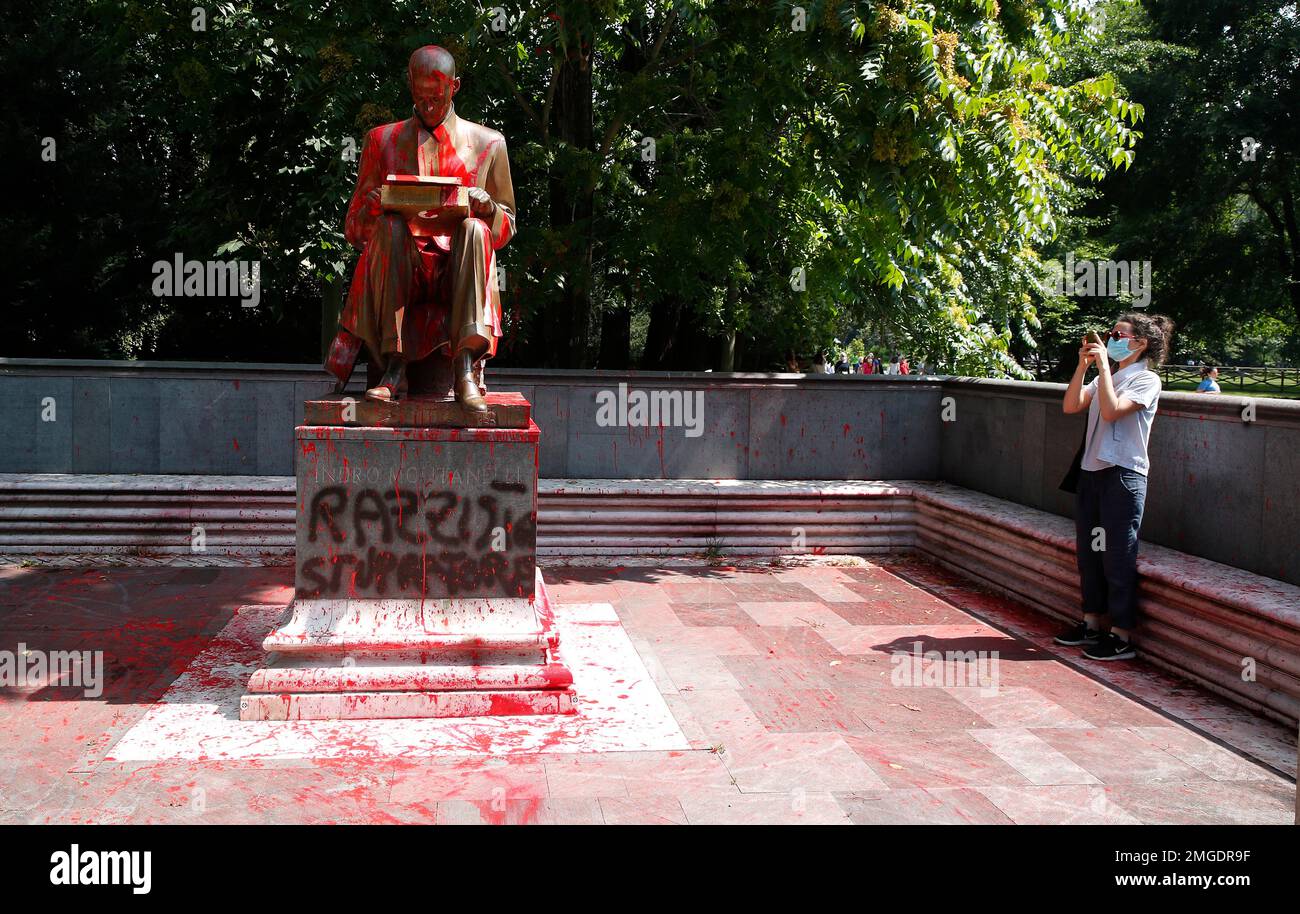 Red paint and writing reading in Italian "racist", top, and "rapist ...