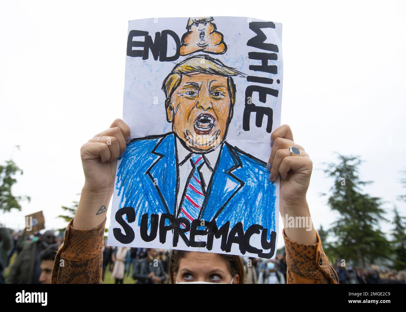 A protestor hod a drawing of U.S. President Donald Trump as thousands ...