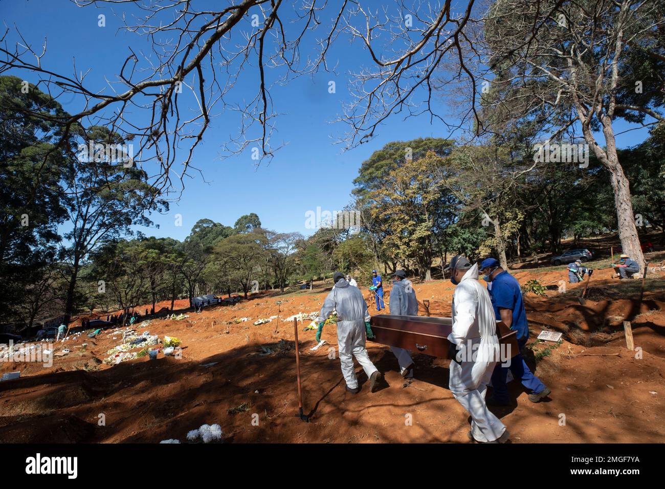 Cemetery workers in protective clothing carry the coffin of a COVID19 ...