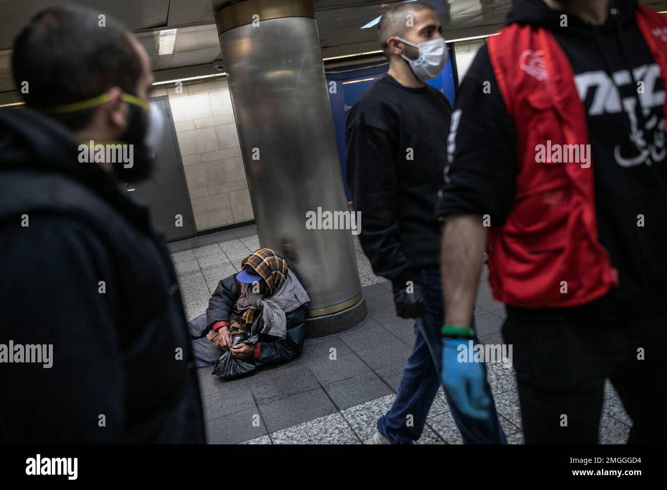 A homeless man in New York's Penn Station opens a packet of food given ...