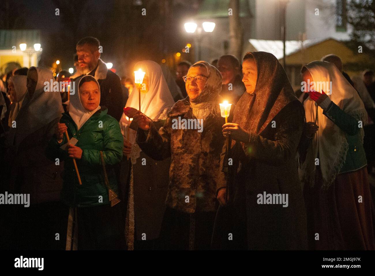 Worshipers hold candles as they attend a religion procession ...
