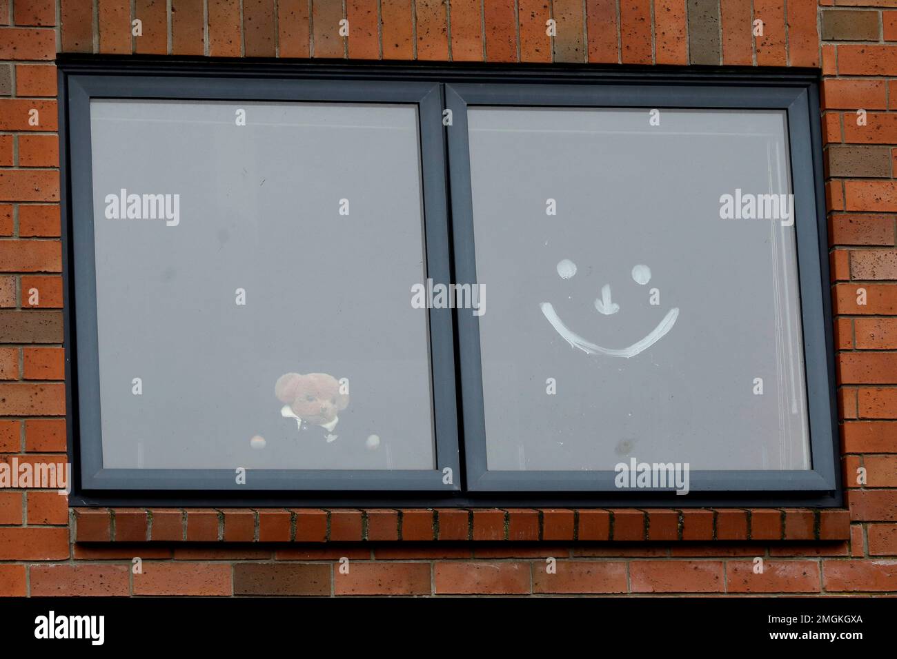 In this Monday, March 30, 2020, photo, a teddy bear sits in a window of ...