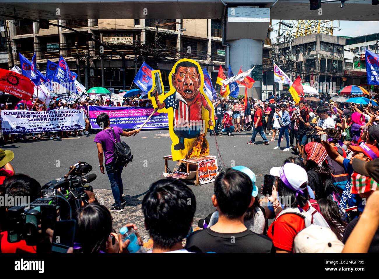 A caricature of Philippine President Rodrigo Duterte is set on fire as ...